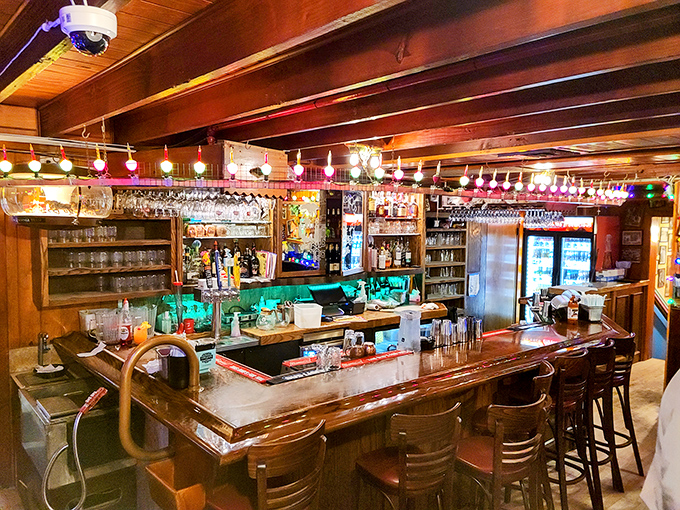 The bar area glows with warm wood and twinkling lights, creating the perfect backdrop for swapping island stories.