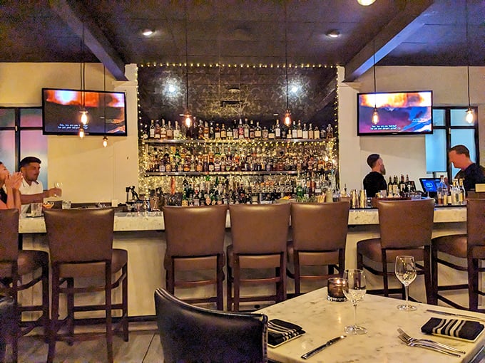The well-stocked bar isn't just impressive—it's a liquid library where mixologists craft stories in a glass.