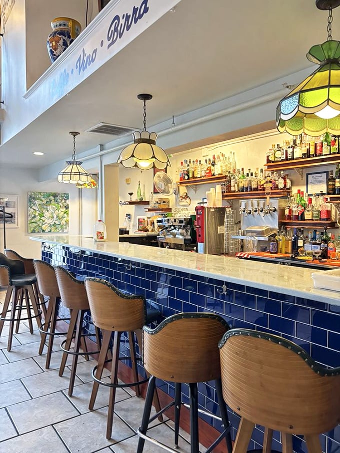 The bar's blue tile front isn't just pretty—it's a Mediterranean daydream where Negronis and spritzes find their perfect home.