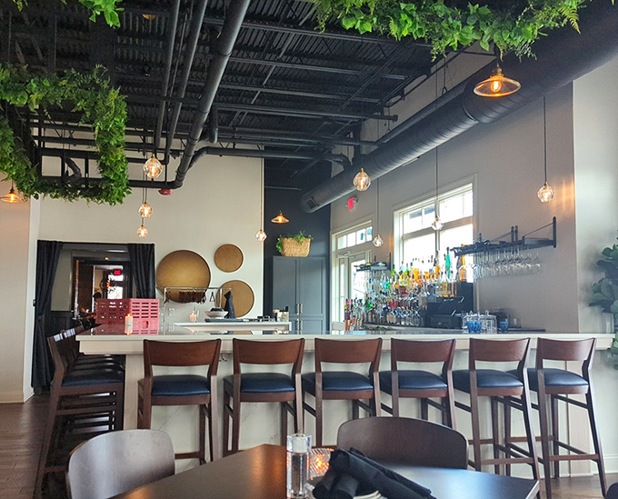 A bar that invites lingering conversations and spontaneous friendships. Those hanging plants create the feeling you've discovered a hidden urban oasis.
