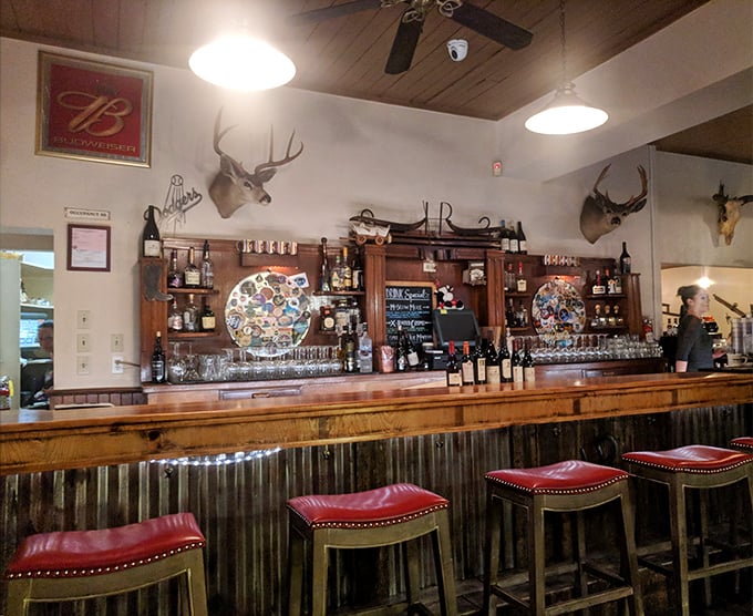 The bar—where cocktails are mixed with confidence and wine glasses await their moment. Those red leather stools have supported generations of happy diners.