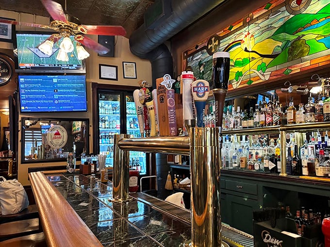 The bar area gleams with polished wood and brass, while stained glass catches the light – a shrine to proper pint-pouring.