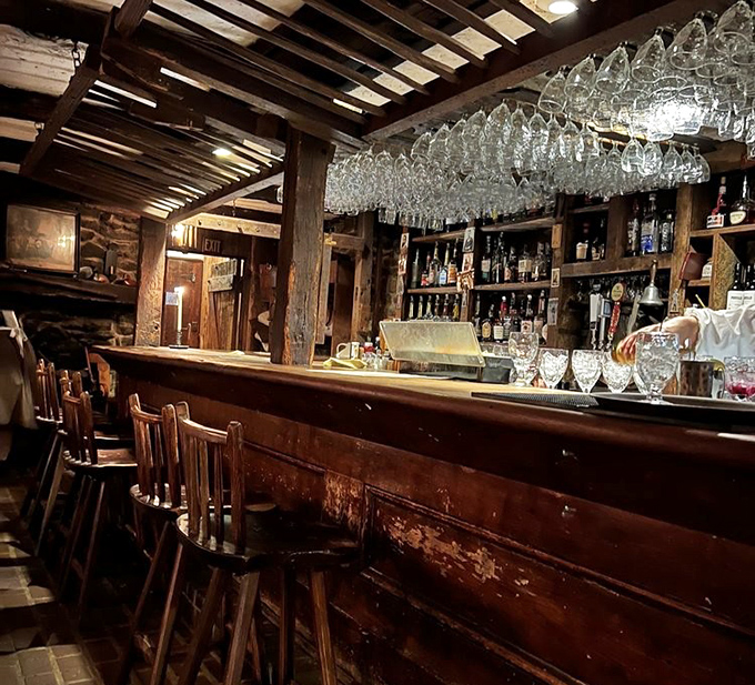 The bar where spirits meet spirits—colonial craftsmanship meets modern mixology under a canopy of gleaming glassware.