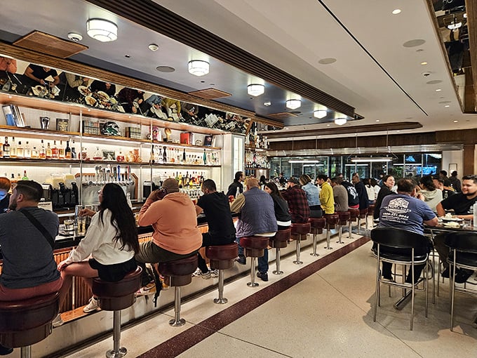 The bar at Tops isn't just a place to sit—it's front-row seats to culinary theater, where cocktails and conversation flow with equal enthusiasm. 