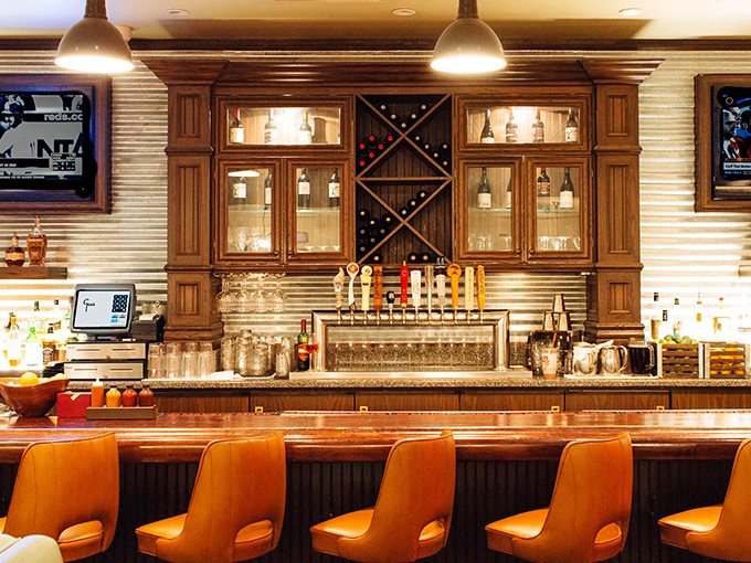 The bar isn't just serving drinks—it's crafting liquid companions for your barbecue journey. That bourbon wall is basically a shrine to good decisions.