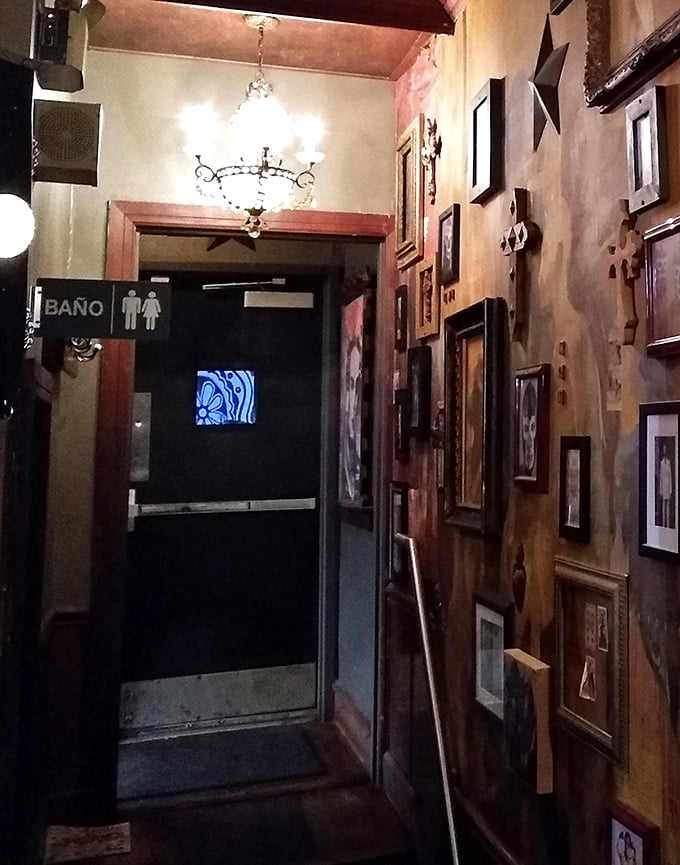 Even the hallway to the restrooms tells a story, with walls adorned in framed art and that unmistakable "Baño" sign pointing the way.