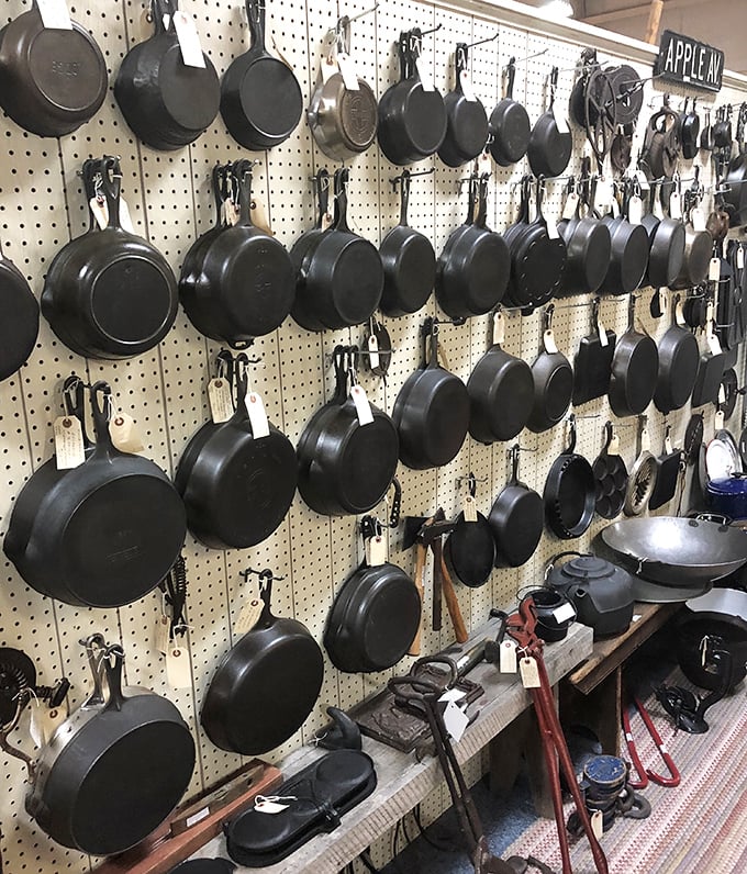 The cast iron wall of fame—seasoned with decades of family dinners. These pans have outlived the stoves they once sat upon.