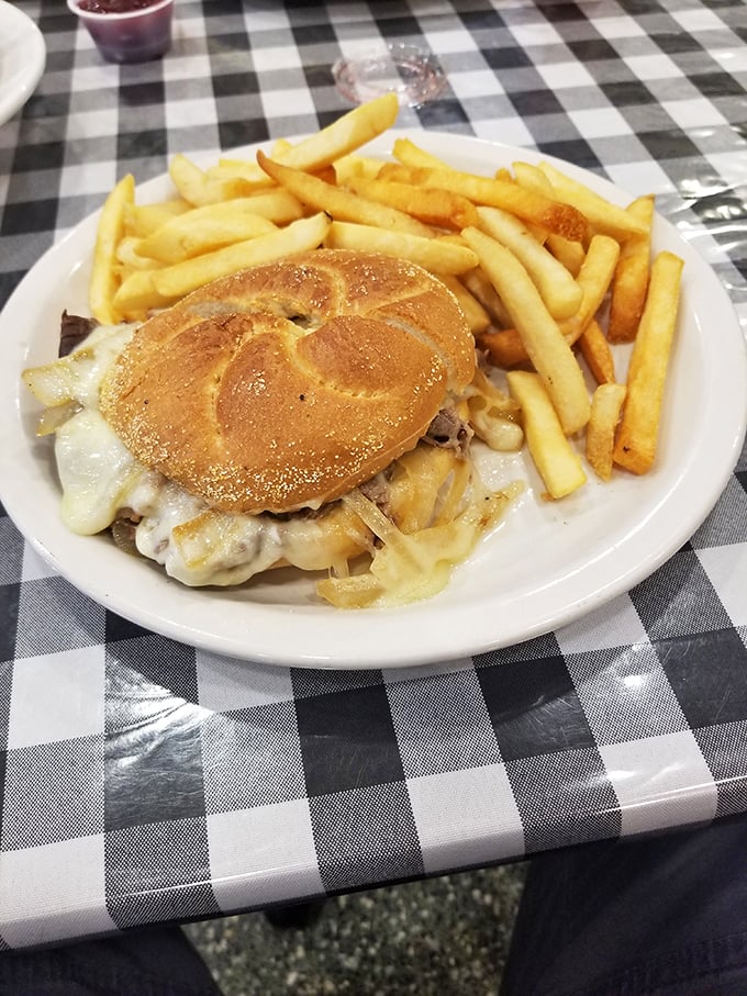 A proper diner patty melt on a checkered tablecloth—where melted cheese meets grilled onions in a union that would make any cardiologist nervous.