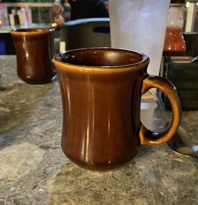 That brown ceramic mug isn't just holding coffee—it's cradling liquid motivation in the vessel that launched a thousand productive mornings.