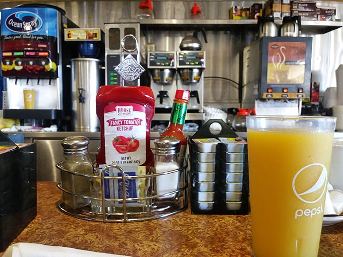 The condiment caddy—that unsung hero of diner dining. Hot sauce, ketchup, and salt and pepper standing at attention, ready for duty.