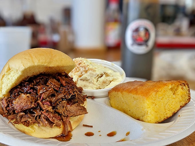 A pulled pork sandwich with coleslaw and cornbread that doesn't need Instagram filters—it's already the supermodel of BBQ plates.