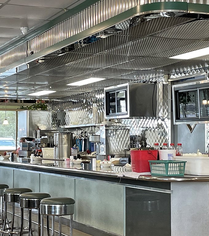 The stainless steel counter and open kitchen—where breakfast dreams are made real before your eyes. This is dinner theater where eggs and bacon are the stars.