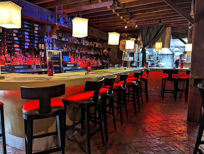 The bar glows with that perfect amber light that makes everyone look good and every drink taste better.