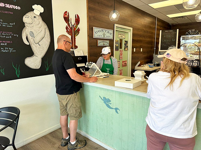 The counter where magic happens daily. That manatee illustration isn't just cute—it's watching to make sure you order dessert.