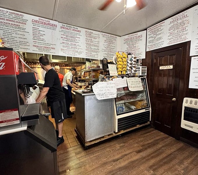 Behind the counter is where the magic happens—skilled hands working with practiced efficiency to create sandwiches worth driving hours for.