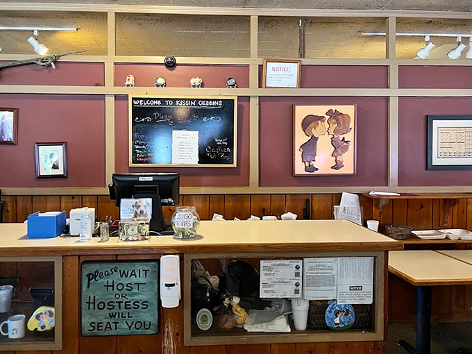The welcoming host station, complete with that charming "Please Wait" sign that's been politely asking for patience since before TikTok was a thing.