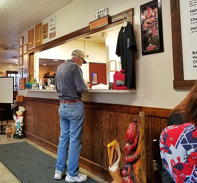 The ordering counter – that magical threshold where hungry patrons transform into soon-to-be-satisfied customers. Racing memorabilia hints at local pride. 
