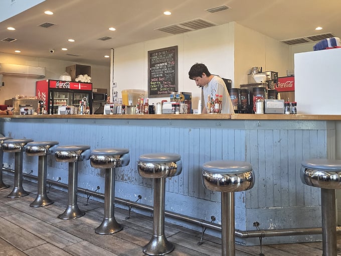 Classic diner counter seating—where solo travelers become temporary locals and the coffee refills come with a side of community.