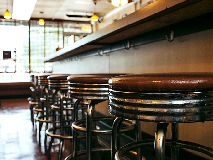 Counter seating where culinary magic unfolds before your eyes – these well-worn stools have supported generations of happy diners.