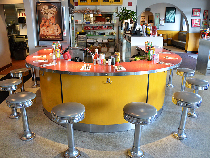 The counter's sunny yellow base and chrome stools aren't just seating—they're front-row tickets to the best food theater in Nashville.