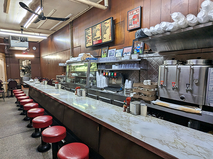 The classic diner counter—where strangers become neighbors and calories don't count. Those red stools have supported generations of satisfied customers.
