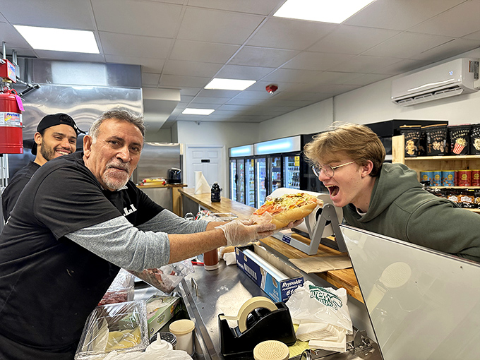 The sandwich handoff – a moment of pure anticipation. The exchange between maker and eater is the prelude to deliciousness.
