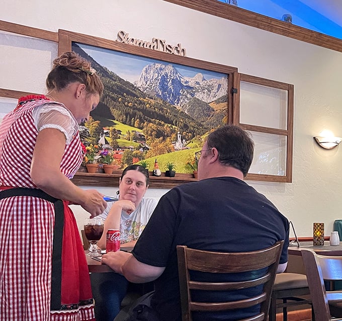 Traditional dirndl-clad servers bring authenticity to your dining experience. That Alpine village backdrop isn't just decoration – it's a promise of culinary transportation.