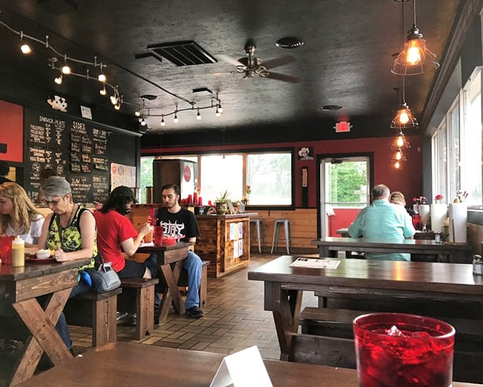 Where barbecue magic happens—simple tables, red walls, and the collective anticipation of everyone waiting for their name to be called.