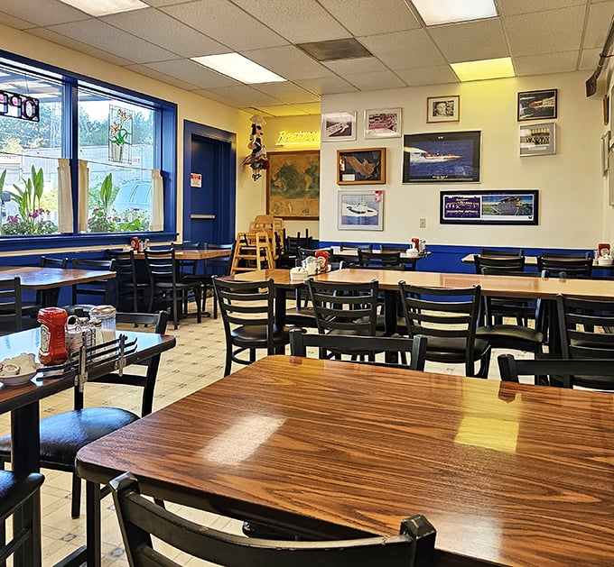 Simple wooden tables, classic diner chairs, and natural light streaming through blue-trimmed windows—breakfast theater at its finest.
