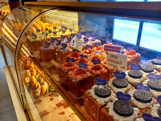 A display case that's essentially Disneyland for adults—colorful croissants and cream-topped confections that make choosing just one nearly impossible.