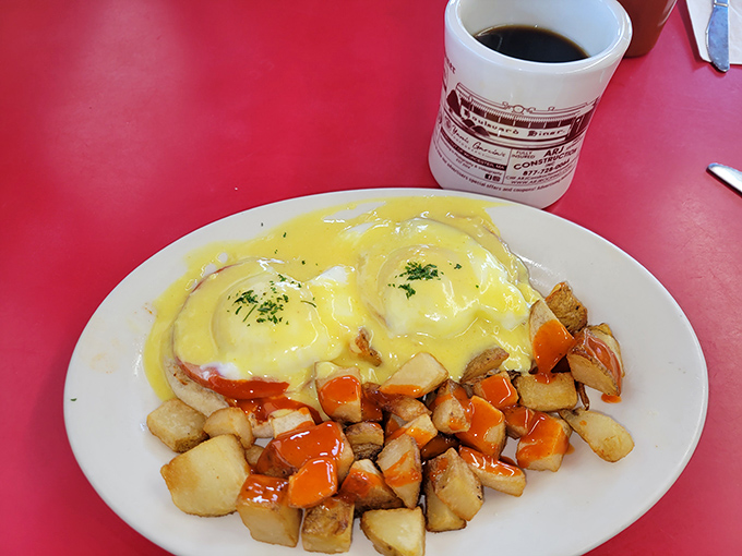 Eggs Benedict done diner-style – hollandaise cascading over English muffins alongside those famous home fries, breakfast elevated without any pretension.