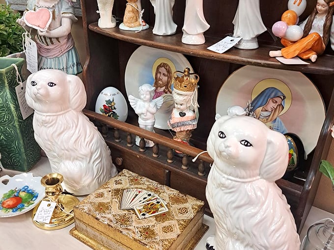 Ceramic figurines and religious icons share shelf space in delightful juxtaposition. Those staffordshire-style cats are giving serious "I'm judging you" vibes.
