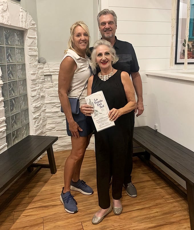 Happy diners showing off their menu—the universal sign of a meal worth remembering and a restaurant worth returning to.