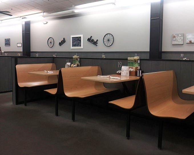 Booths designed for lingering conversations and second cups of coffee. Notice the bicycle wheels on the wall – quirky touches that feel just right.