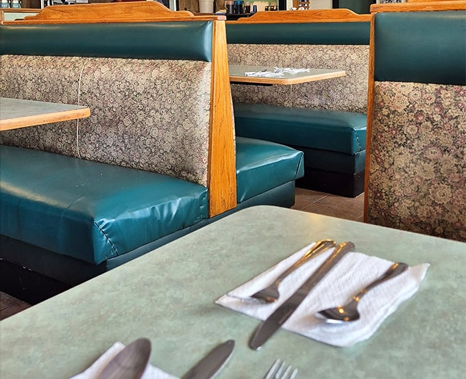 These booths have cradled Tampa's hungry masses through countless breakfast rushes. The teal vinyl and wood dividers create private kingdoms for pancake enthusiasts.