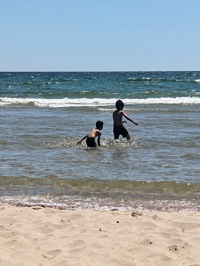 Summer's ultimate joy—children discovering the thrill of cool lake waters on a hot day, creating memories that will outlast any video game.