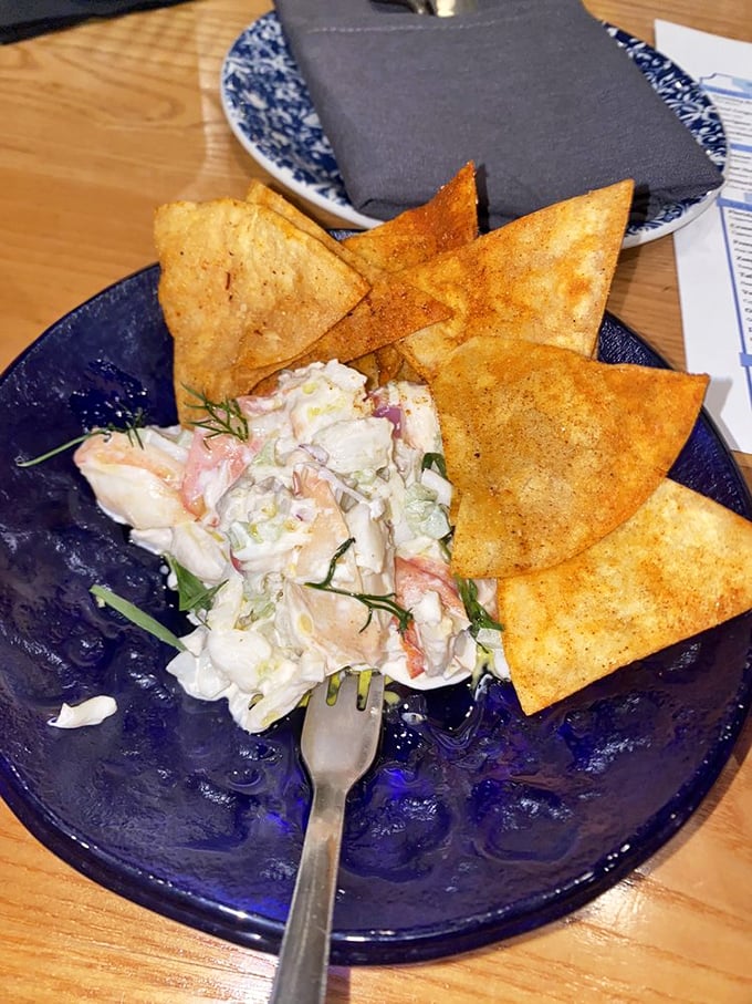 Seafood salad and crispy chips on that signature blue plate—like ocean treasures washed ashore, but tastier and with less sand.