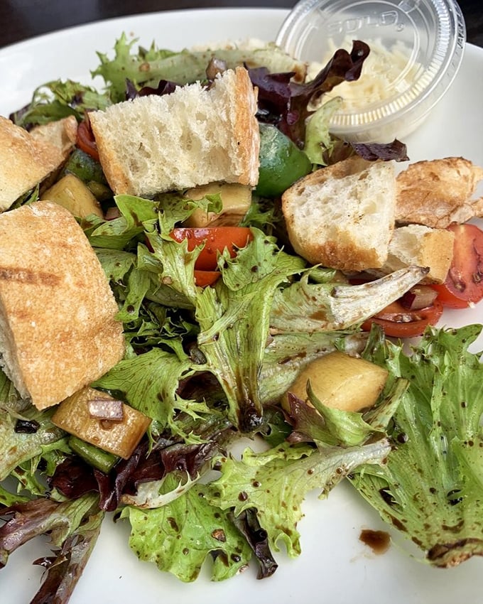 Even the salad deserves attention – fresh greens, tomatoes, and those perfect cubes of cheese that make vegetables suddenly very interesting.