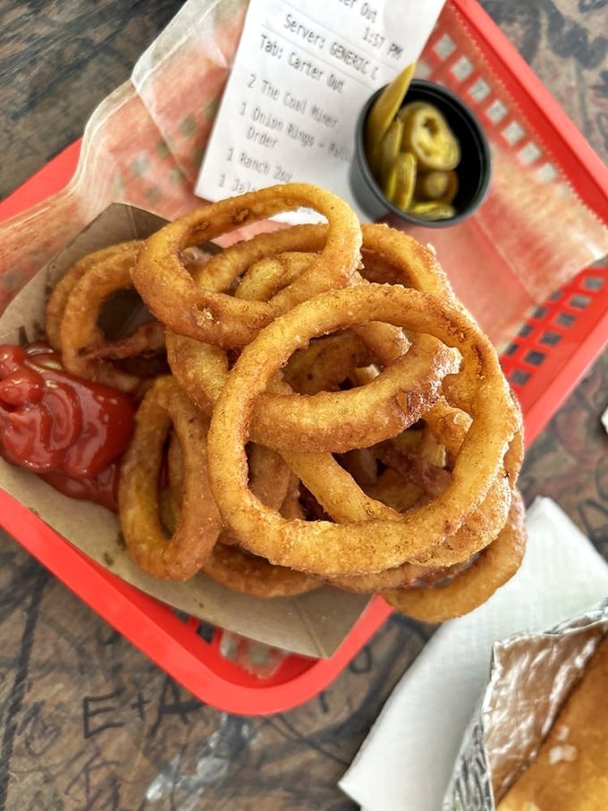 Golden onion rings stacked like delicious jewelry. Crispy on the outside, tender within—the way all good things should be.