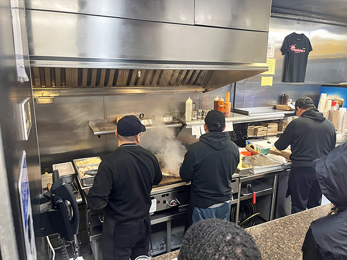 Kitchen choreography at its finest—the grill masters working their magic in a steam-filled dance of spatulas and sizzle.