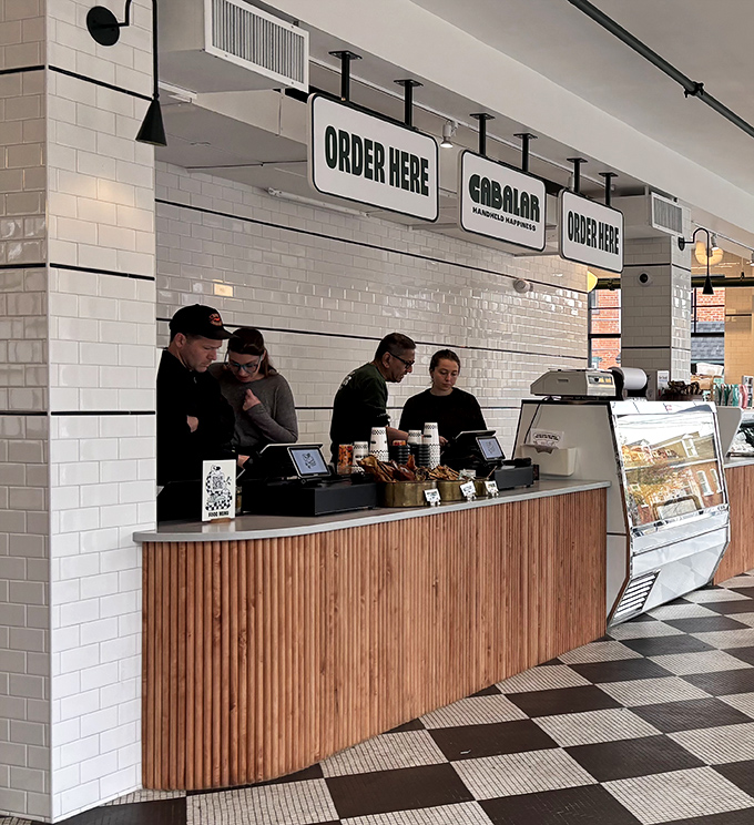 "Order Here" signs that might as well say "Happiness This Way." The wooden counter adds warmth to the industrial-chic aesthetic.