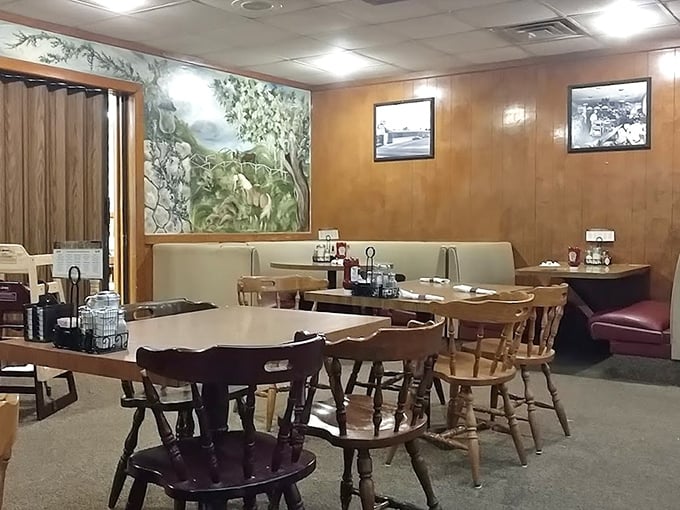 Another dining room corner reveals a pastoral mural—because nothing complements pancakes quite like a peaceful countryside scene painted decades ago.