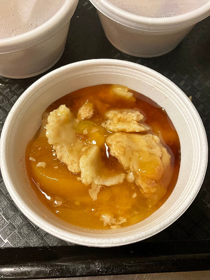Peach cobbler swimming in its own sweet juices—proof that sometimes the simplest desserts deliver the most profound pleasure. Southern comfort in a cup.