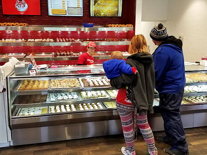 The family donut selection process—a delicate negotiation where everyone wins, especially the kid eyeing that chocolate-frosted beauty.