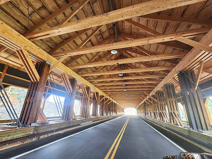 Inside the covered bridge, wooden beams create a cathedral-like passage that transforms an ordinary drive into an architectural experience worth savoring.