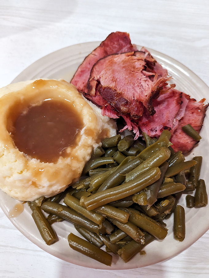 Tender ham, garden-fresh green beans, and mashed potatoes with gravy – the holy trinity of Midwest comfort that feels like a warm hug on a plate.