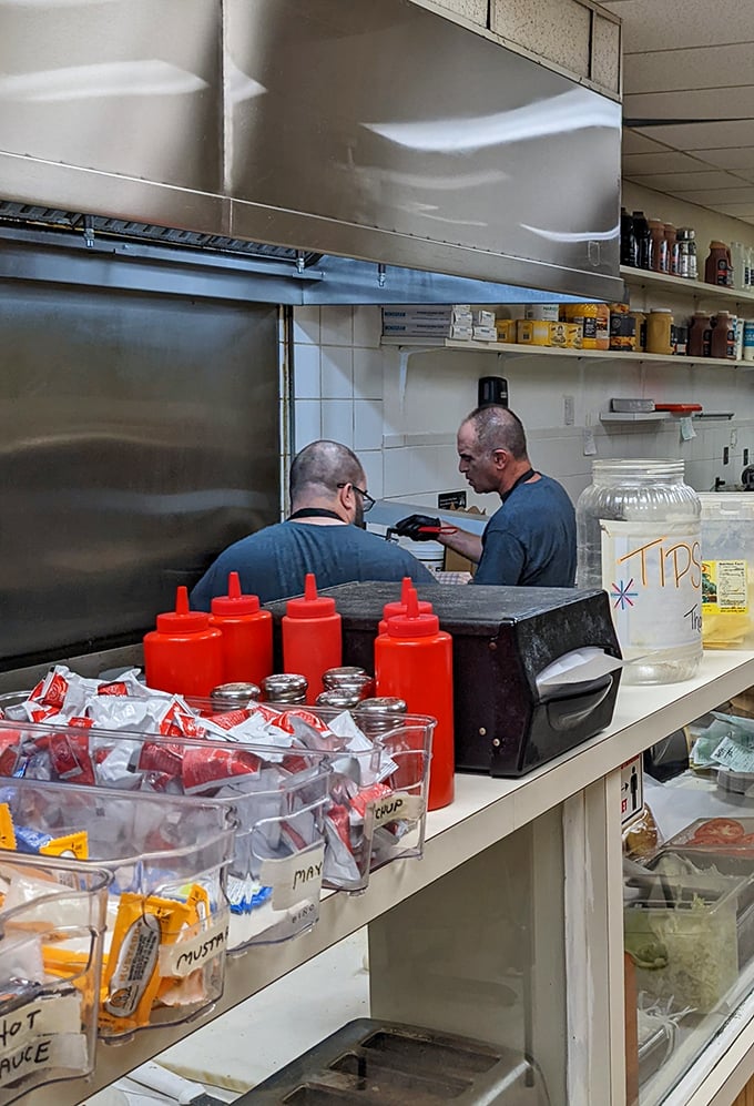 Behind the scenes where sandwich magic happens. Those squeeze bottles aren't just condiment containers—they're flavor wands in the right hands.
