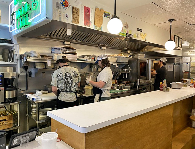 The kitchen crew in action—sandwich architects working their magic behind the counter with the focus of brain surgeons and the flair of jazz musicians.