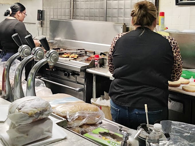 Behind the counter, the real magic happens—skilled hands working the grill with the confidence that comes from thousands of perfectly flipped patties.