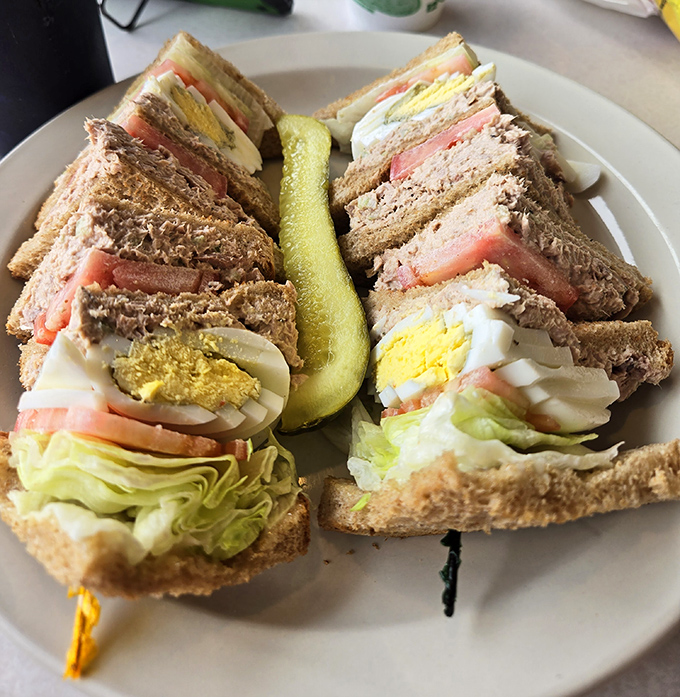 The club sandwich—architecture you can eat, where each precisely cut triangle reveals layers of careful construction and timeless appeal.